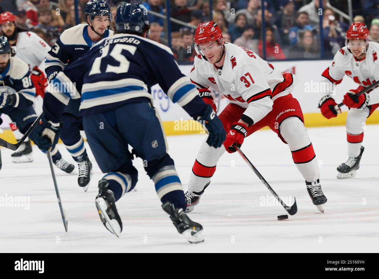 Carolina Hurricanes' Andrei Svechnikov, right, carries the puck across center ice as Columbus ...