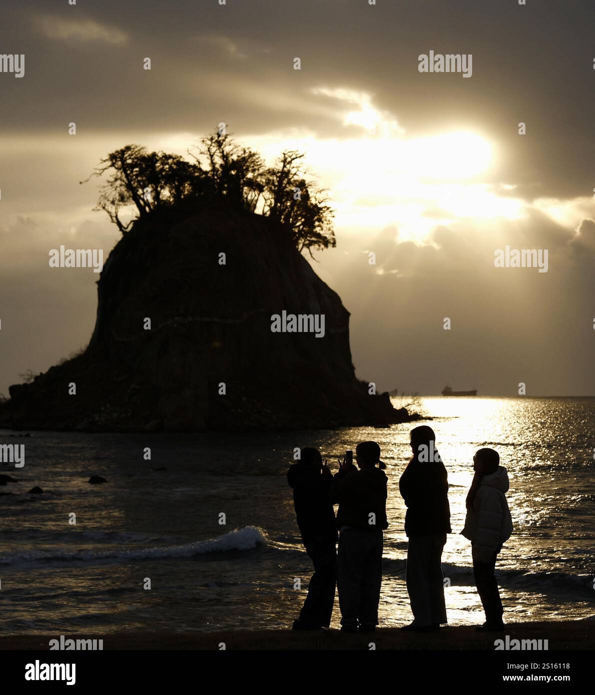 People stand on a shore in Suzu, Ishikawa Prefecture, on Jan. 1, 2025 ...