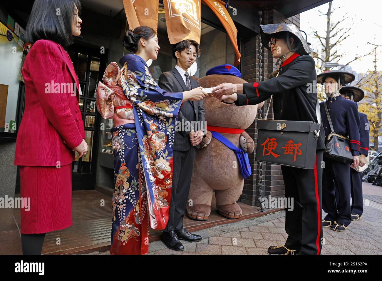 A postal worker in a uniform worn by Meiji-era mailmen delivers New ...