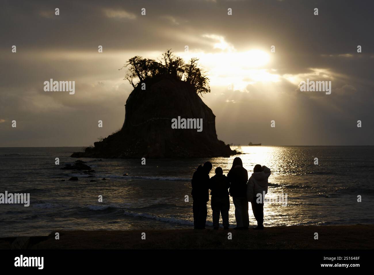 People stand on a shore in Suzu, Ishikawa Prefecture, on Jan. 1, 2025 ...