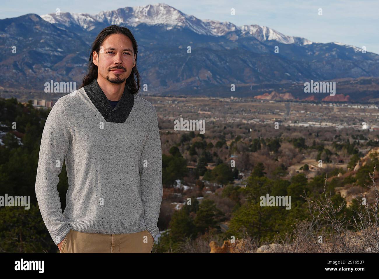 Lane Belone poses with Pikes Peak in the background on an overlook in ...