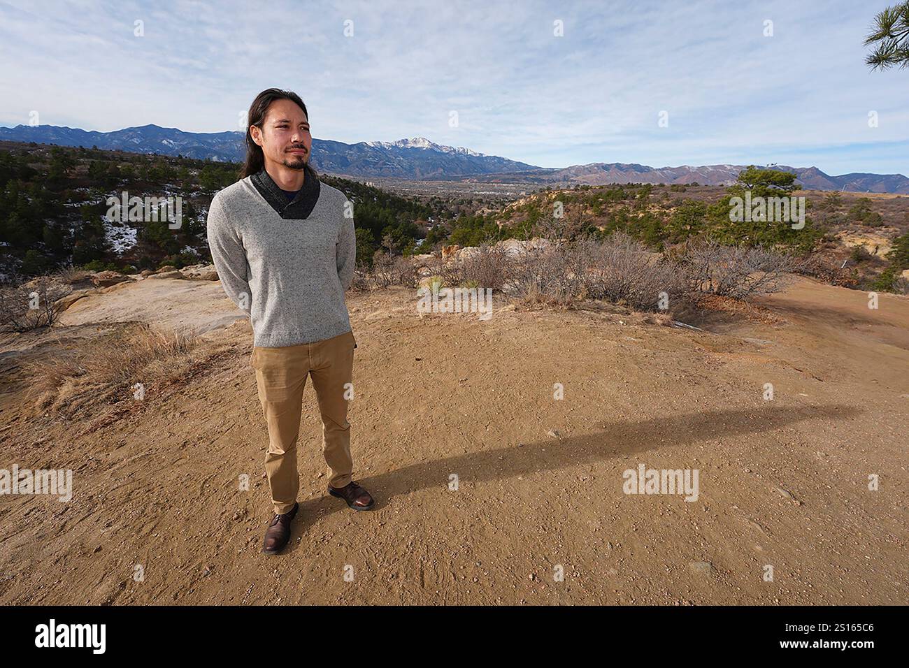 Lane Belone poses with Pikes Peak in the background on an overlook in ...