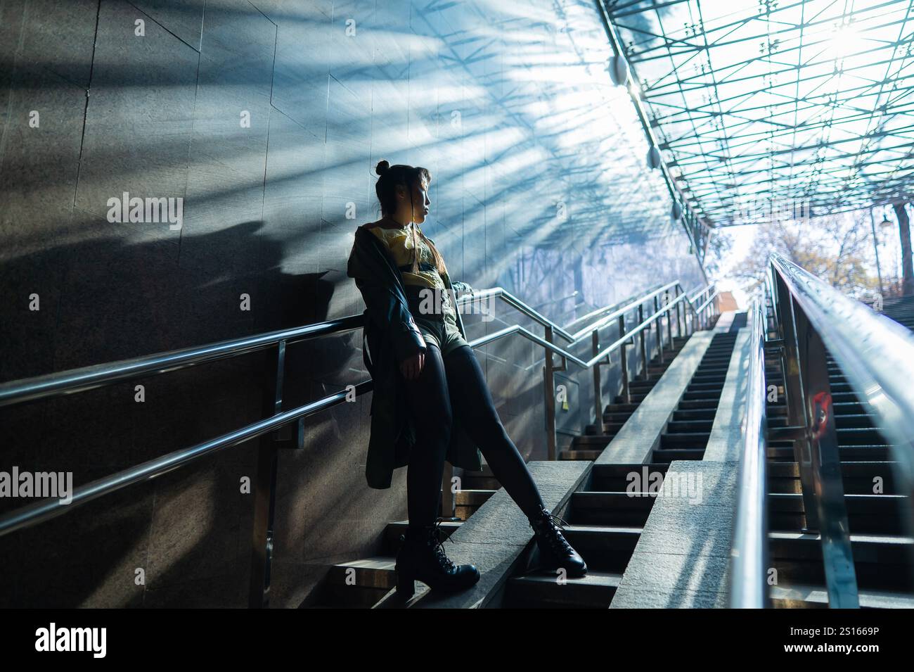 Portrait of a young Asian woman posing in the subway near the stairs ...