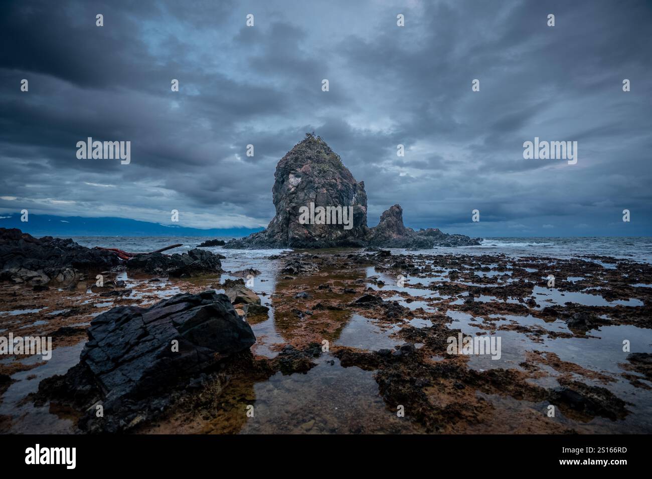 A dramatic coastal scene of Diguisit, Aurora featuring two rugged rock ...