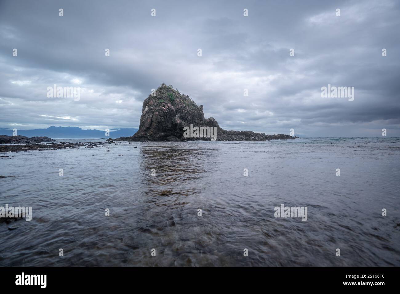 A dramatic coastal scene of Diguisit, Aurora featuring two rugged rock ...