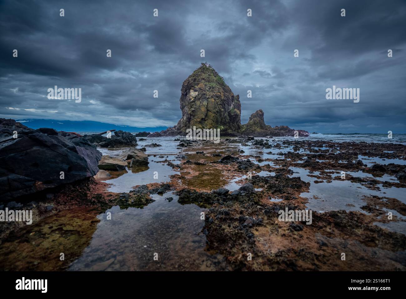 A dramatic coastal scene of Diguisit, Aurora featuring two rugged rock ...