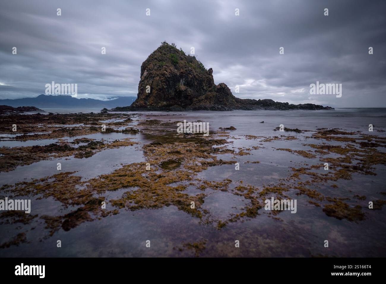 A dramatic coastal scene of Diguisit, Aurora featuring two rugged rock ...