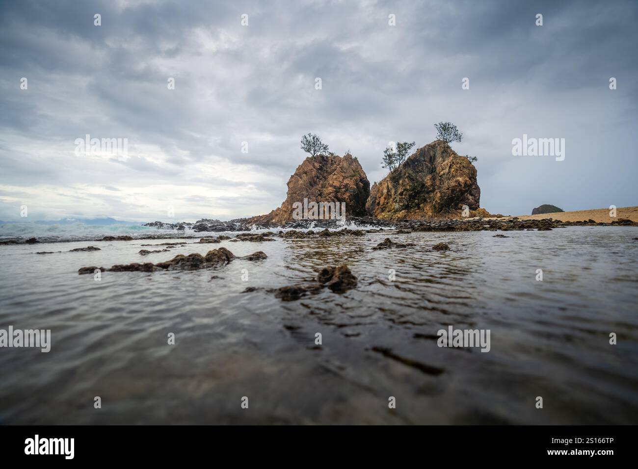 A dramatic coastal scene of Diguisit, Aurora featuring two rugged rock ...