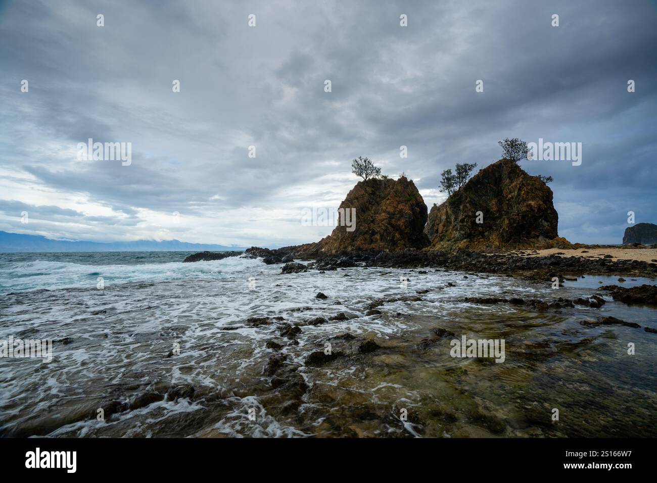A dramatic coastal scene of Diguisit, Aurora featuring two rugged rock ...
