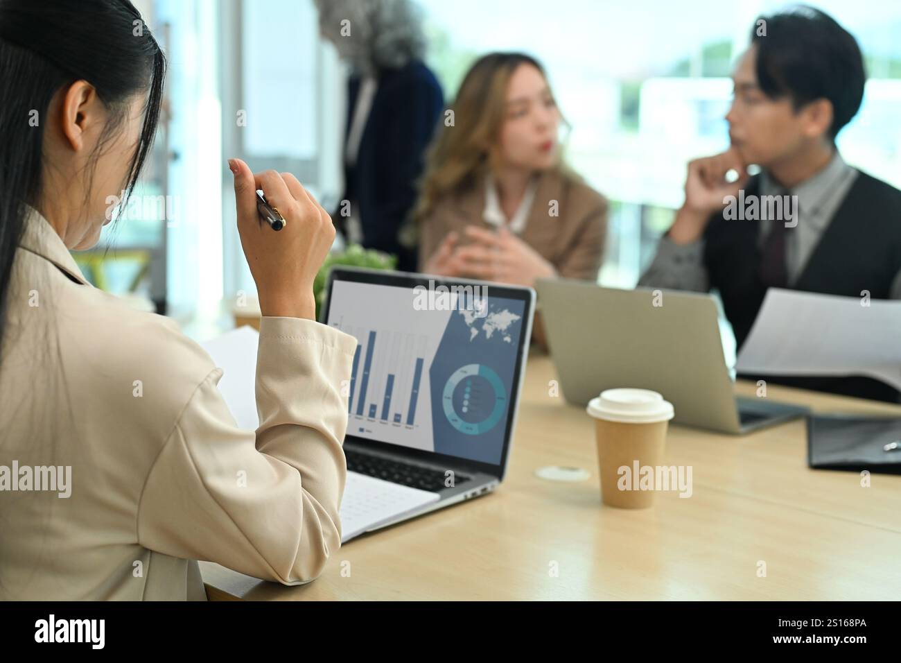 Professional businesswoman reviewing statistical charts on her laptop ...