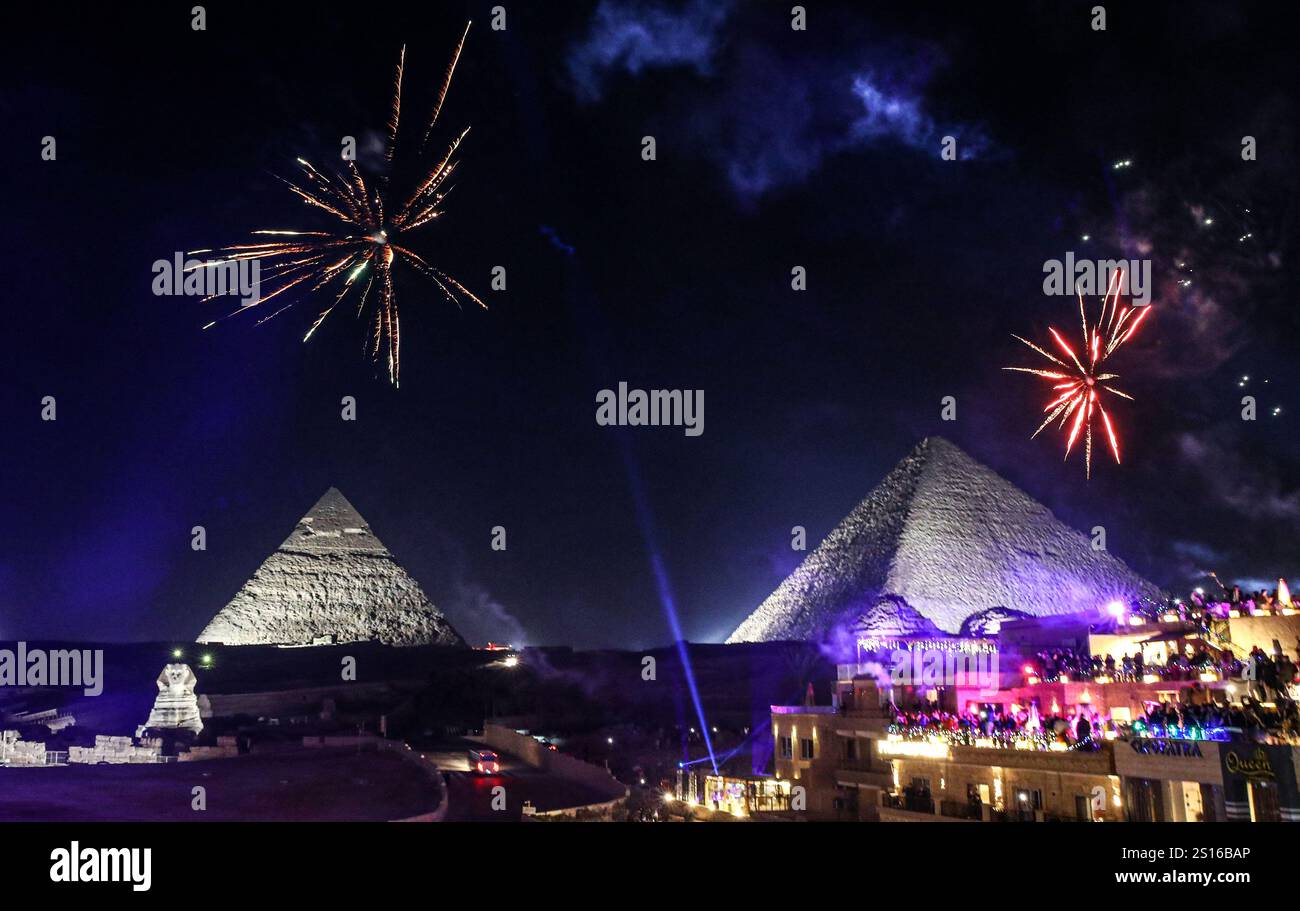 Giza, Egypt. 31st Dec, 2024. Fireworks explode over the Giza Pyramids ...