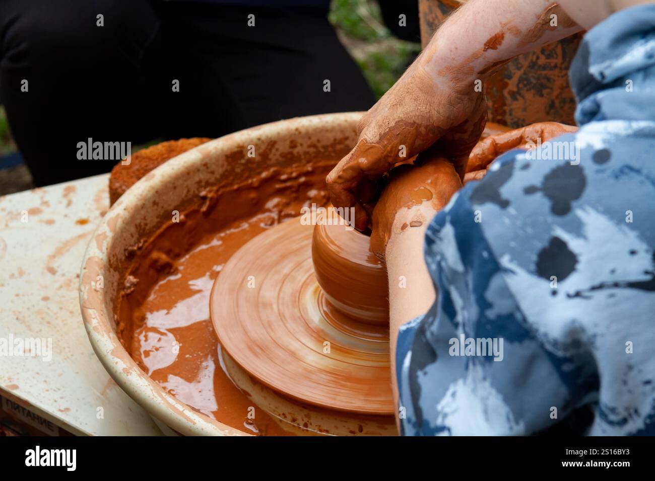 Pottery training. Rotating a clay pot on a machine. Hands knead clay ...