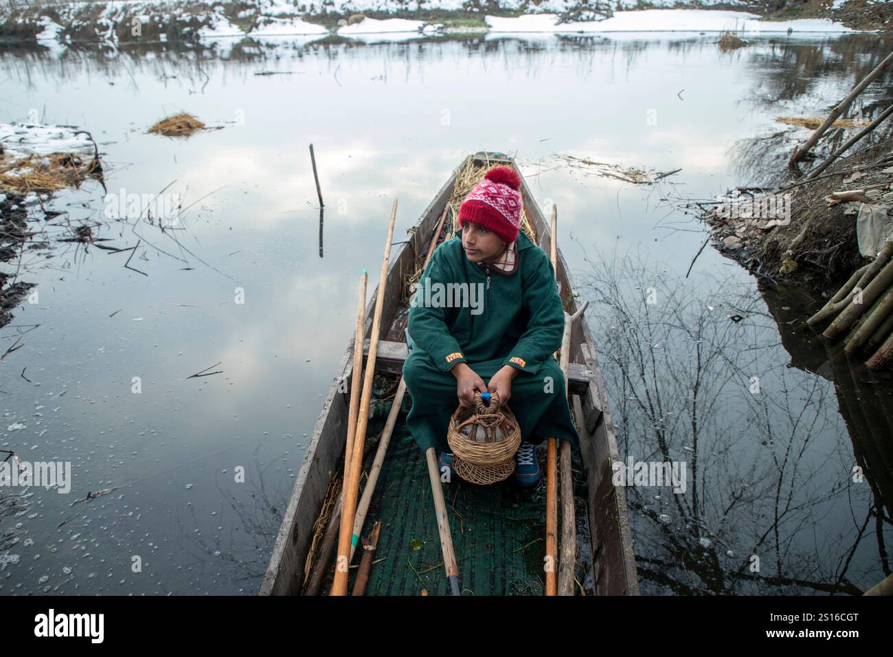 Ganderbal, India. 01st Jan, 2025. A Kashmiri warms his hands on a fire ...
