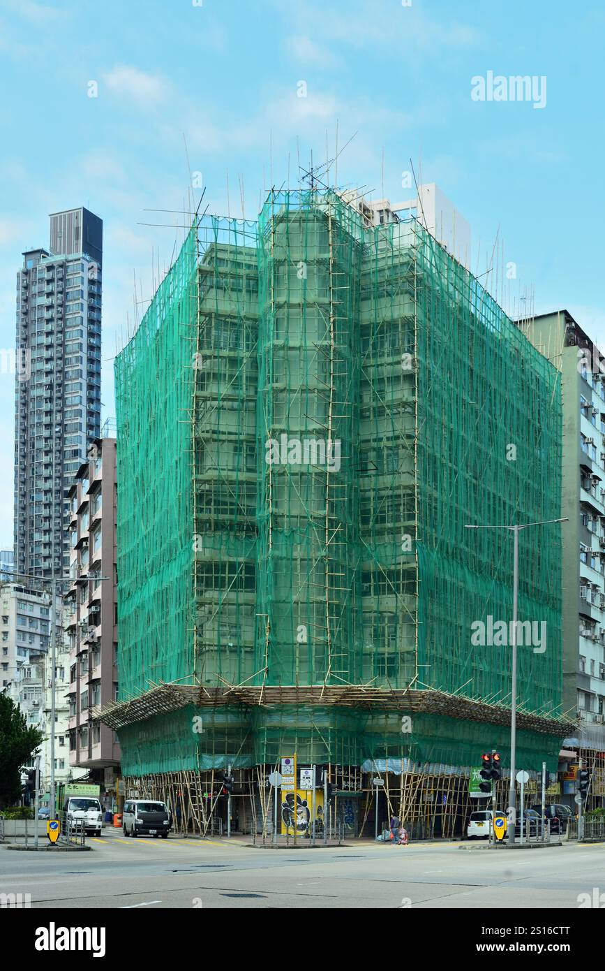 Building under renovation completely covered by bamboo scaffold and ...