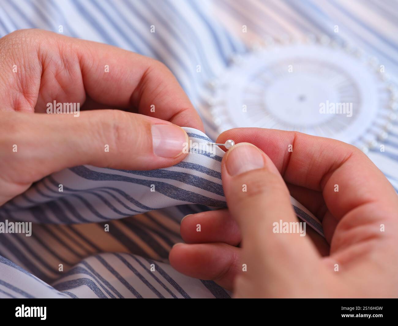 Woman hands using a sewing push pin on the striped clothes Stock Photo ...