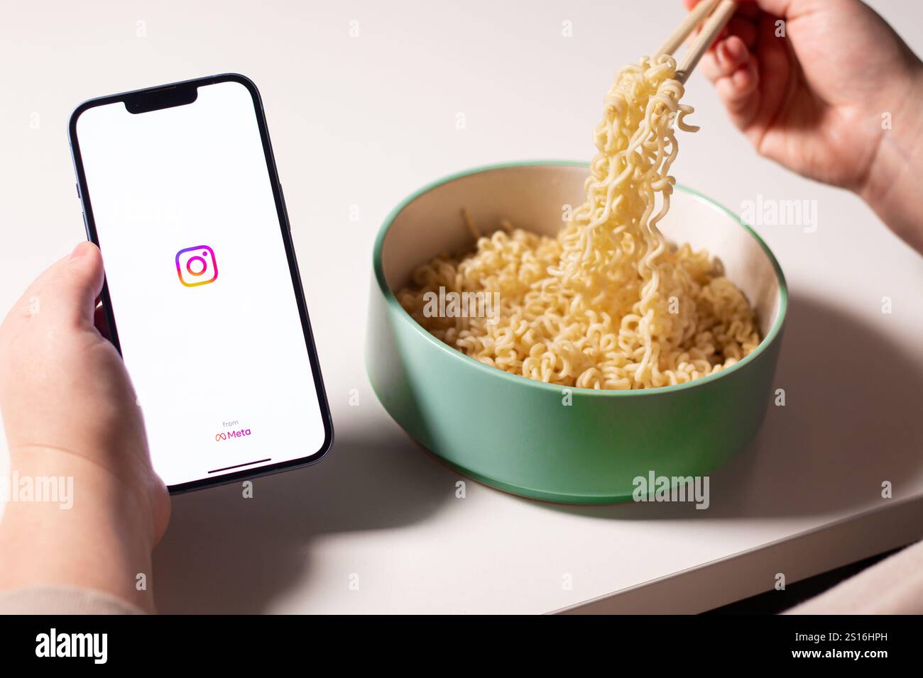 Female using instagram app on smartphone while eating pasta at home ...