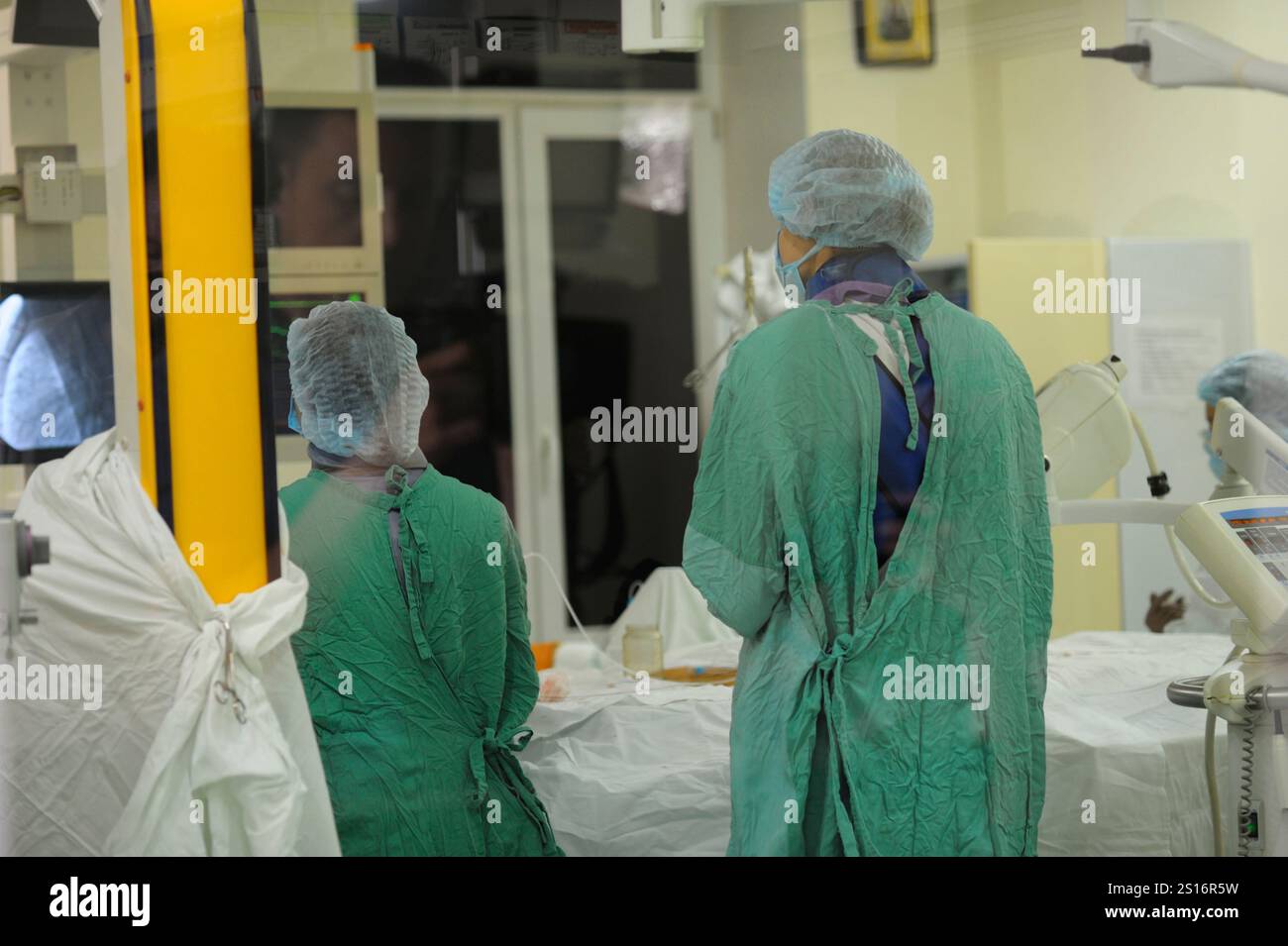 Operating theatre. Surgeons standing around patient plate and ...
