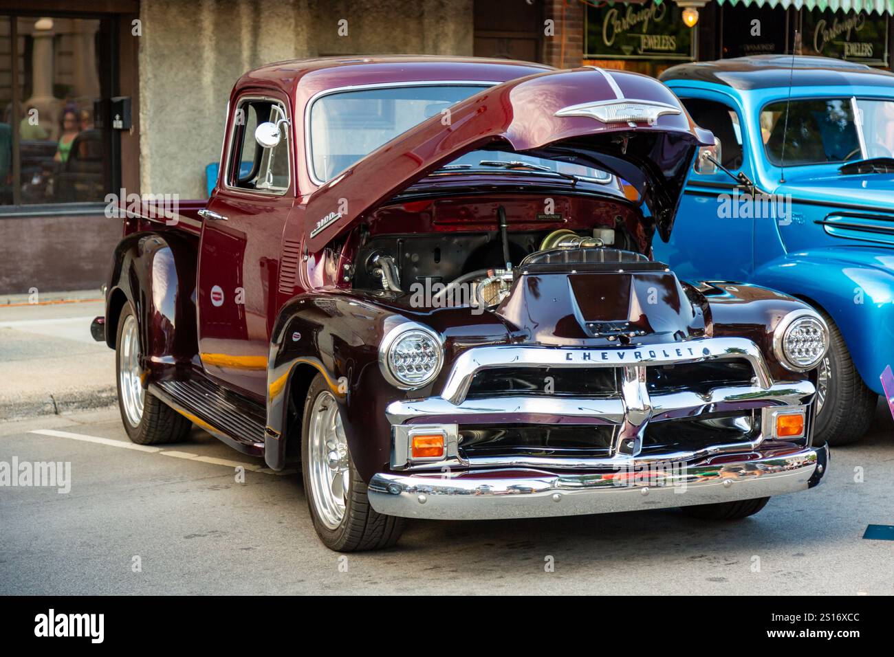 A two-tone maroon 1954 Chevrolet 3100 pickup truck on display at a car ...