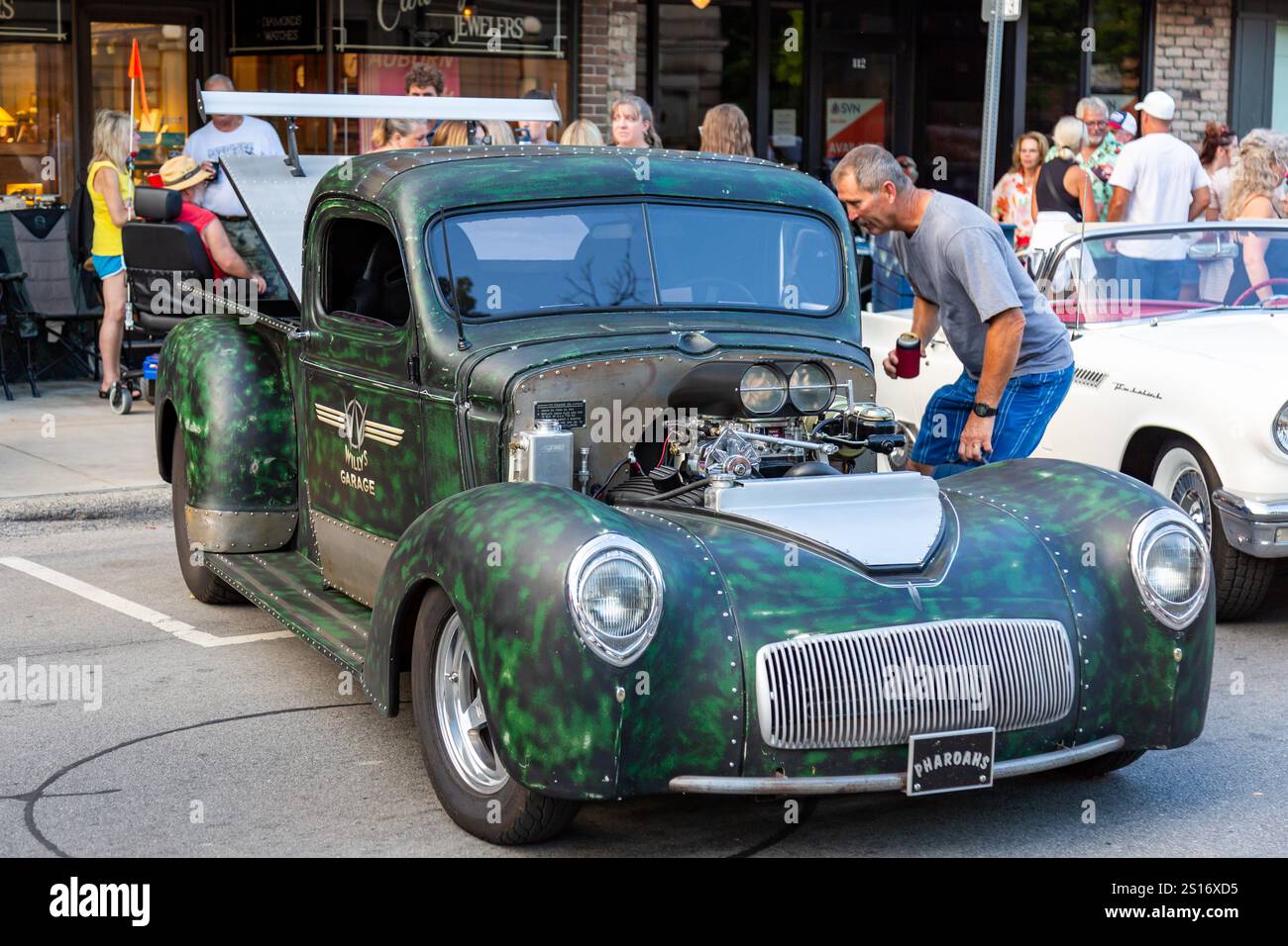 A modified green 1941 or 1942 Willys pickup truck on display at a car ...