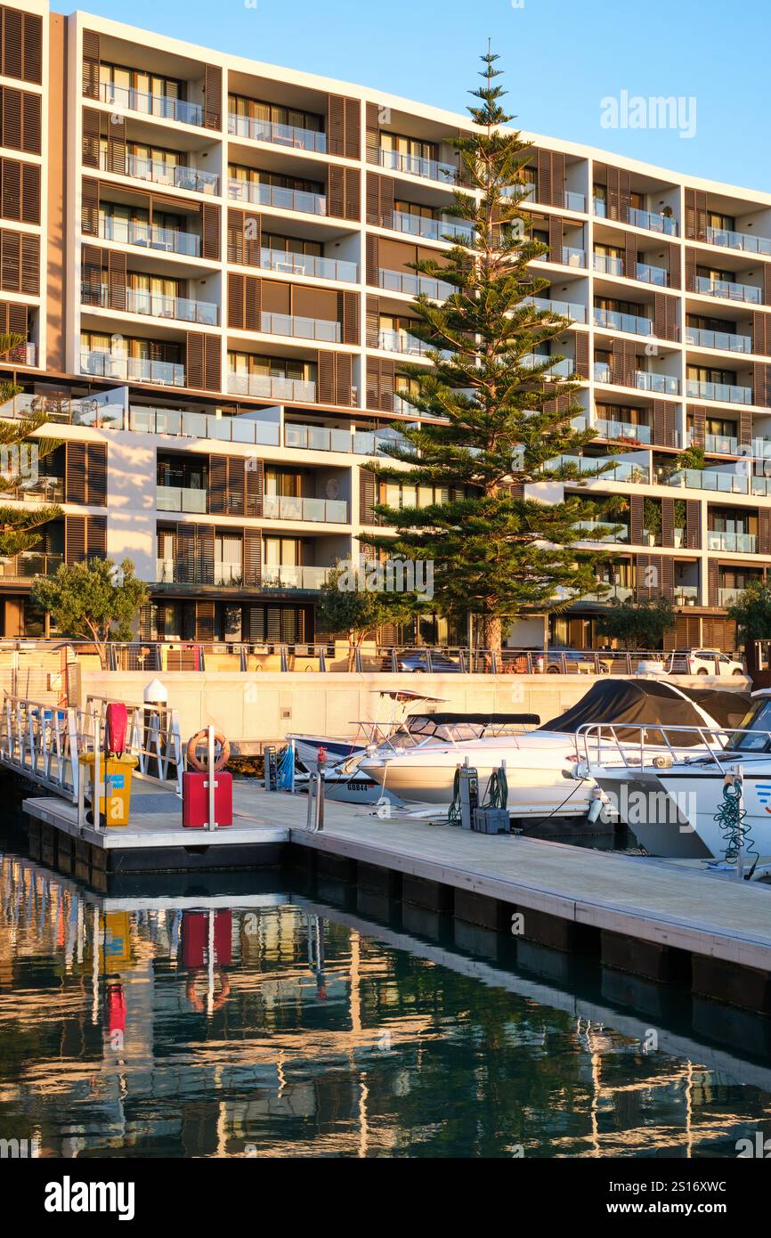 Boats and reflections in front of a modern apartment complex in the ...