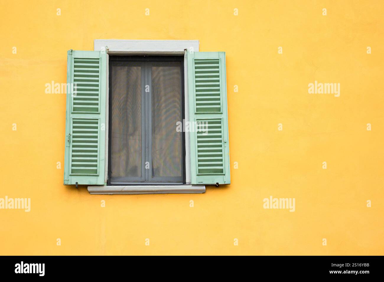 Facade of old yellow building with shuttered windows Stock Photo - Alamy