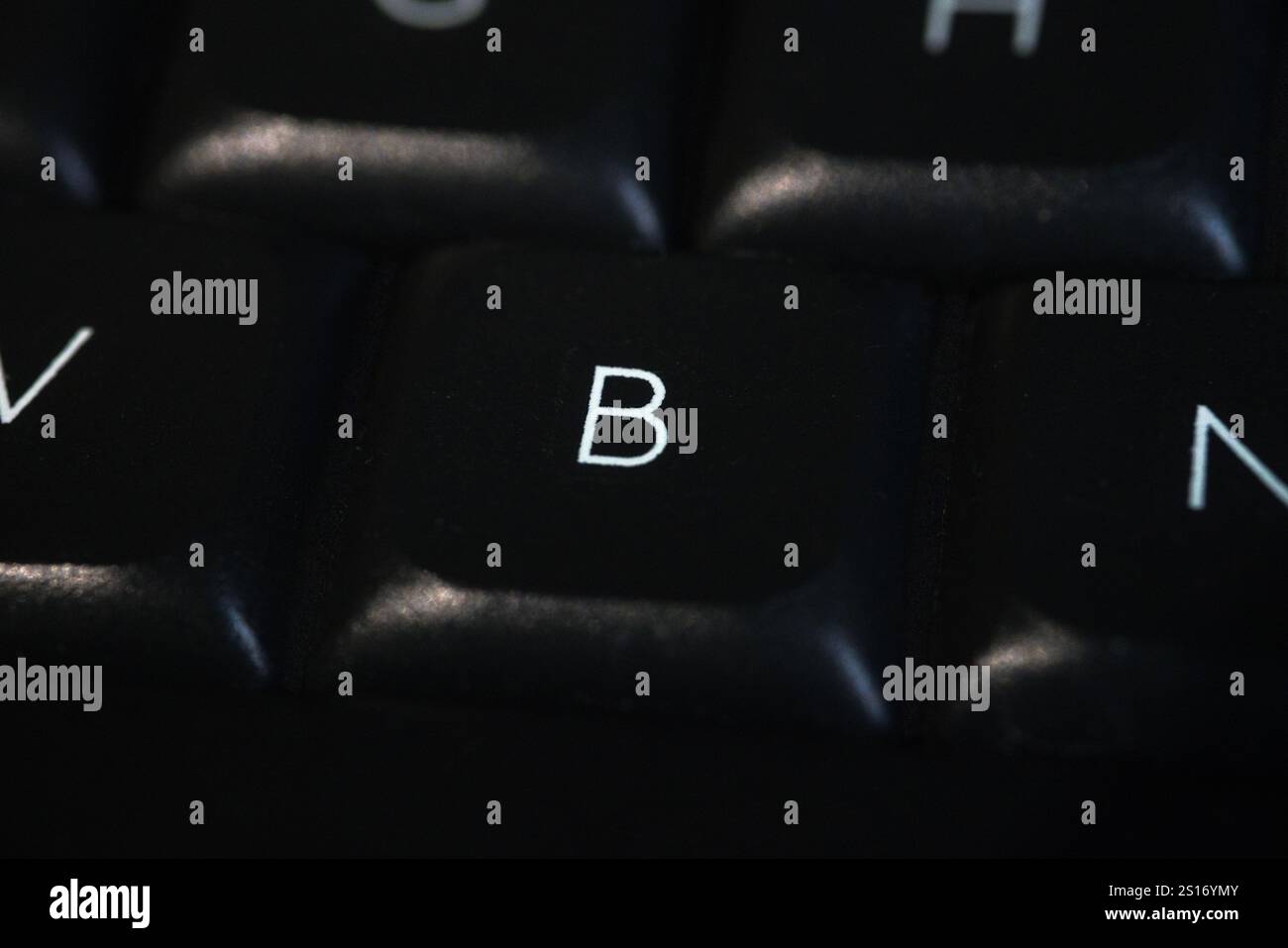 A detailed close up photo of the letter B key on a sleek black keyboard ...