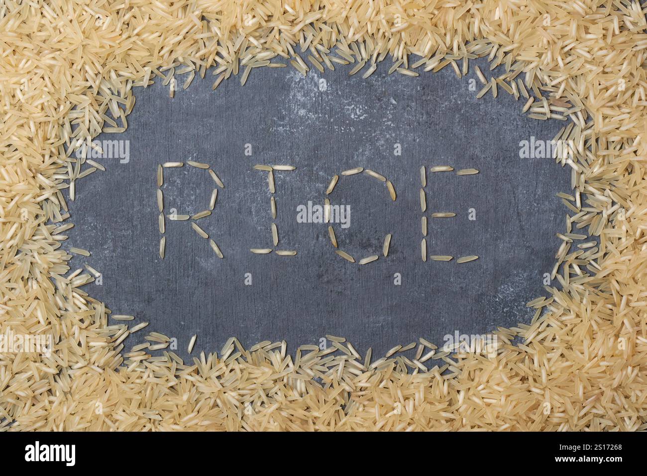 word rice with raw rice grains on textured black surface background ...
