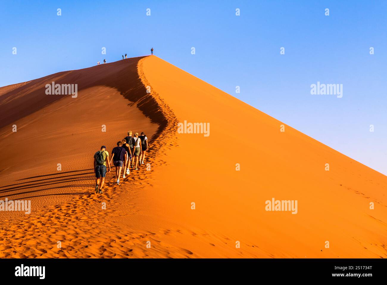 SESRIEM, NAMIBIA - AUGUST 21, 2024: Family with Backpacks climbing Dune ...