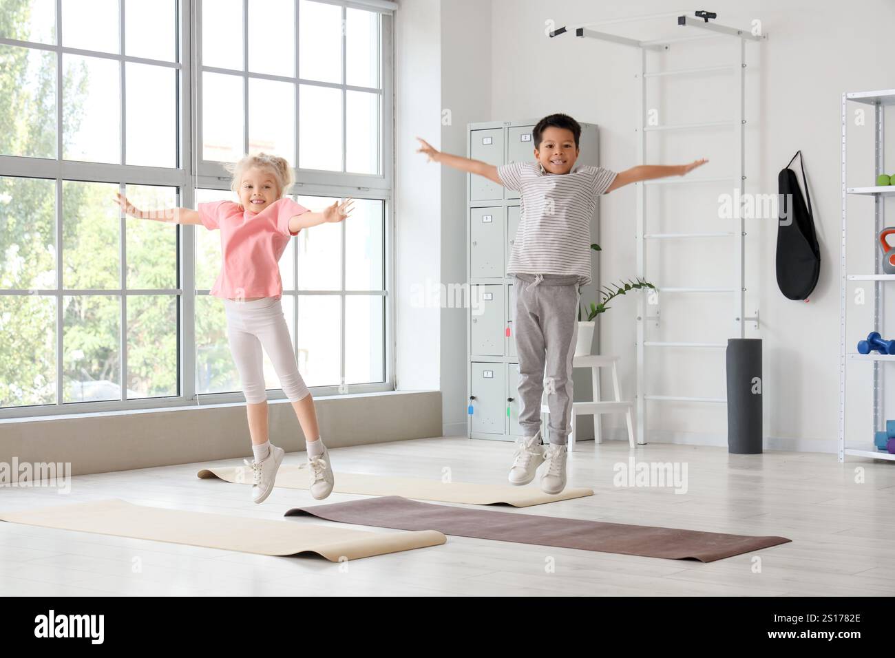 Cute little children jumping in gym Stock Photo - Alamy