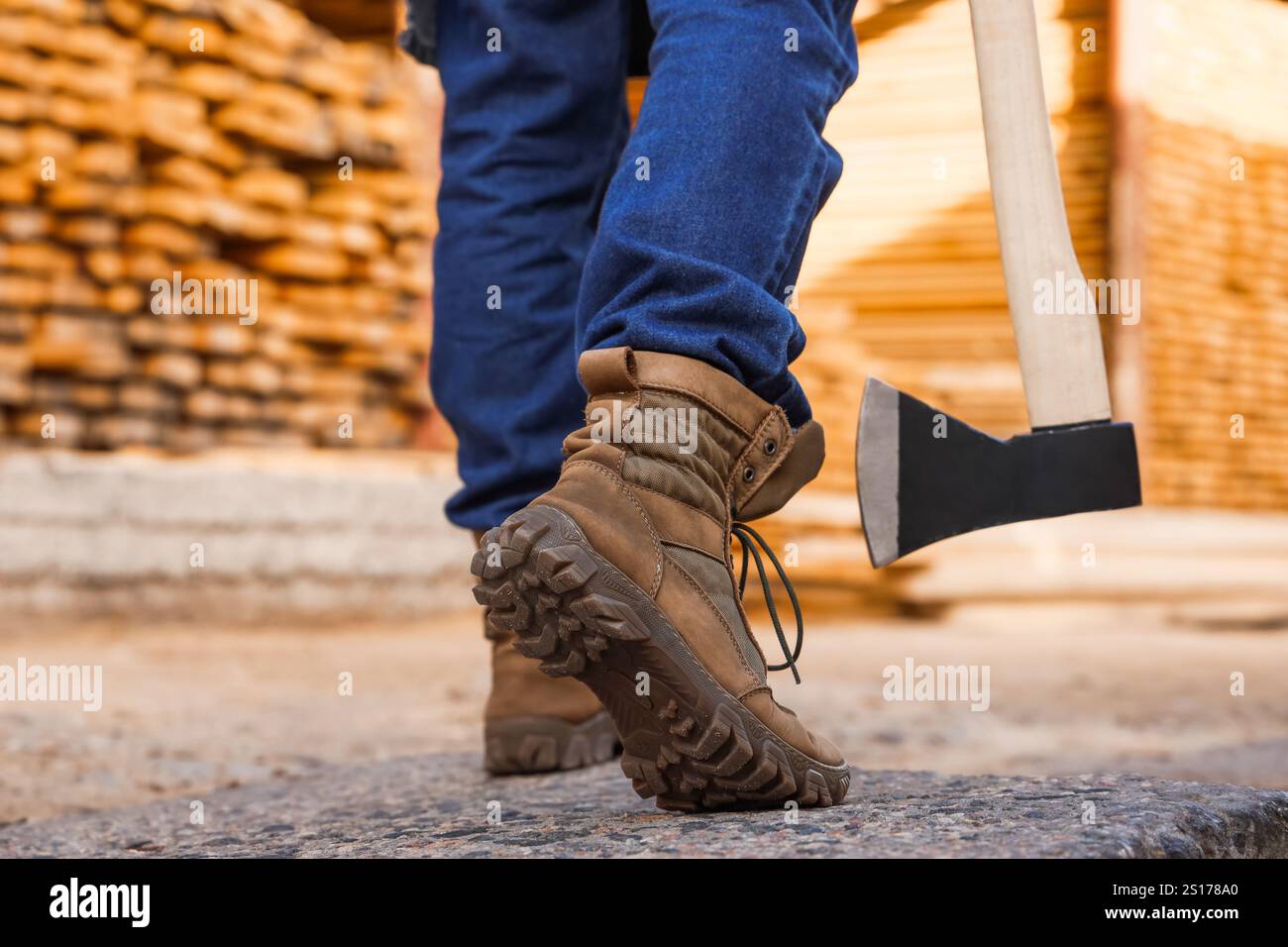 Male carpenter with axe walking at sawmill, back view Stock Photo - Alamy