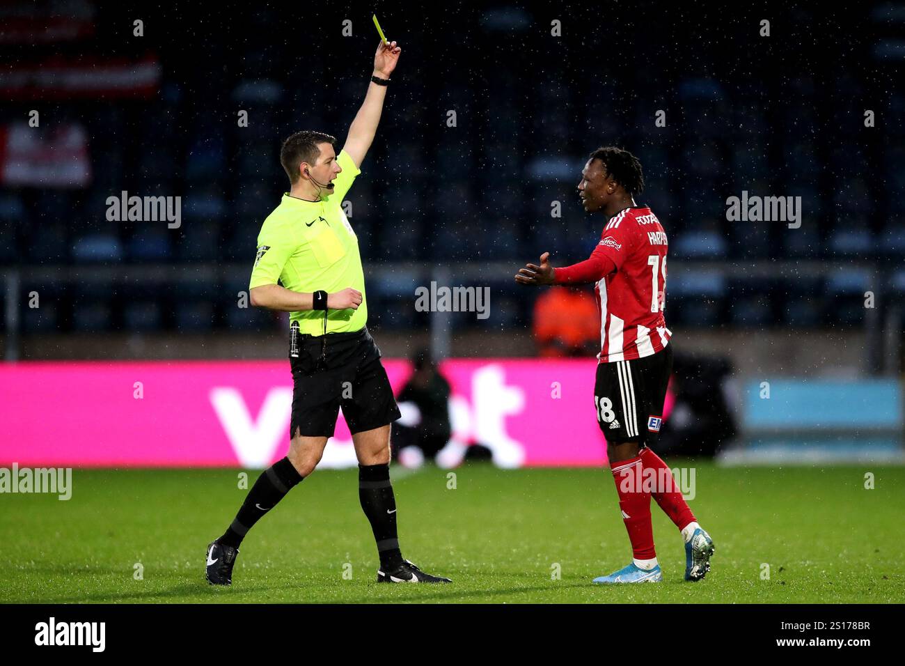 Referee Scott Simpson shows a yellow card to Exeter City's Vincent ...