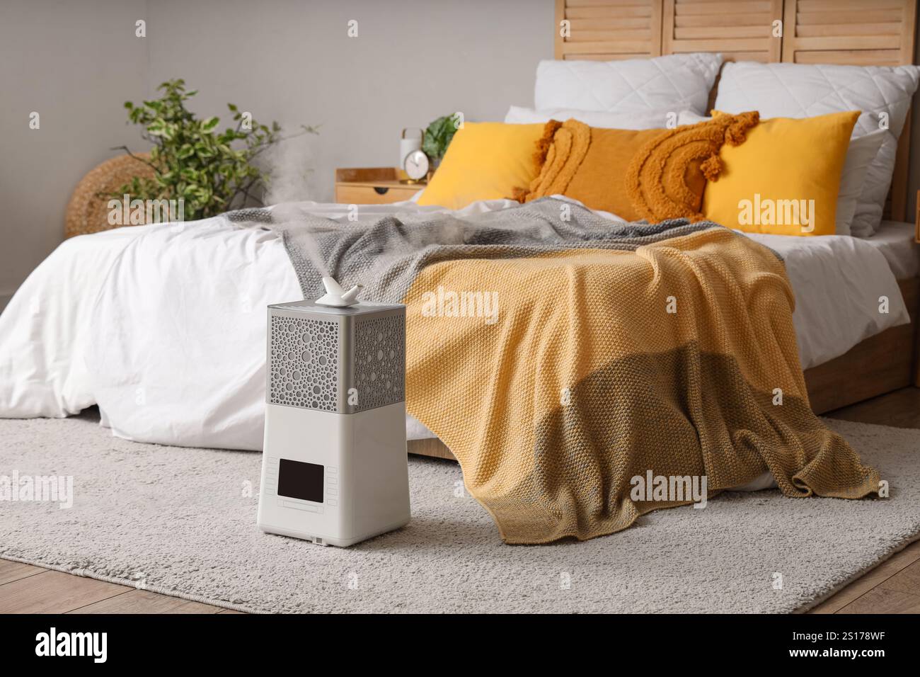 Interior of bedroom with modern humidifier on floor near bed Stock ...
