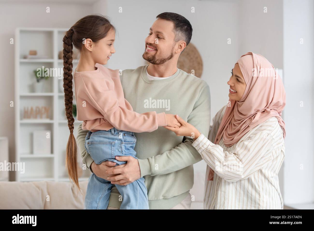 Muslim parents with their daughter at home Stock Photo - Alamy