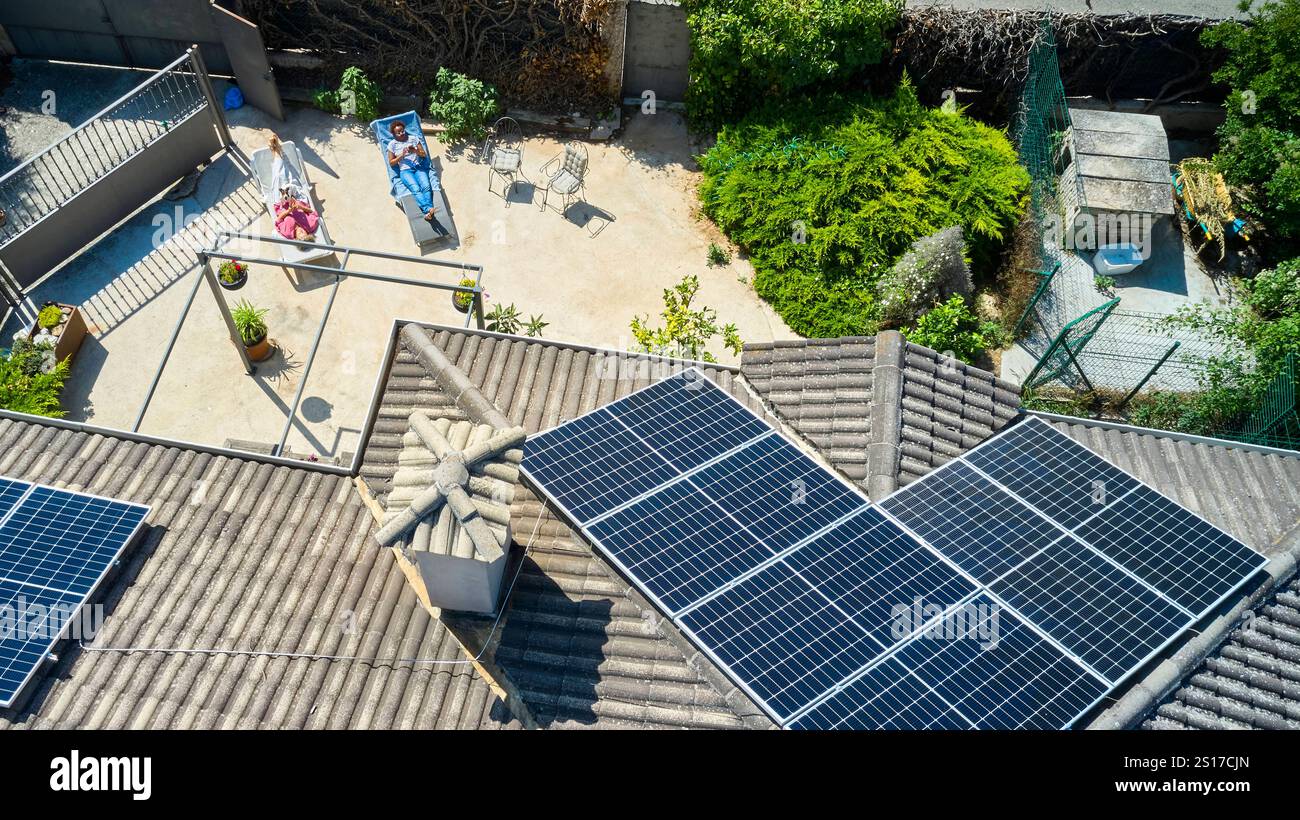 An aerial view shows two women sunbathing in a sunny backyard while ...