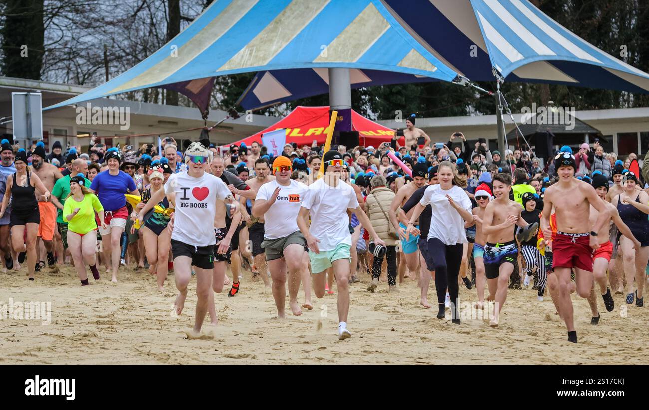 Haltern, Germany. 01st Jan, 2025. The swimmers race to the water. Participants, many in costumes ...