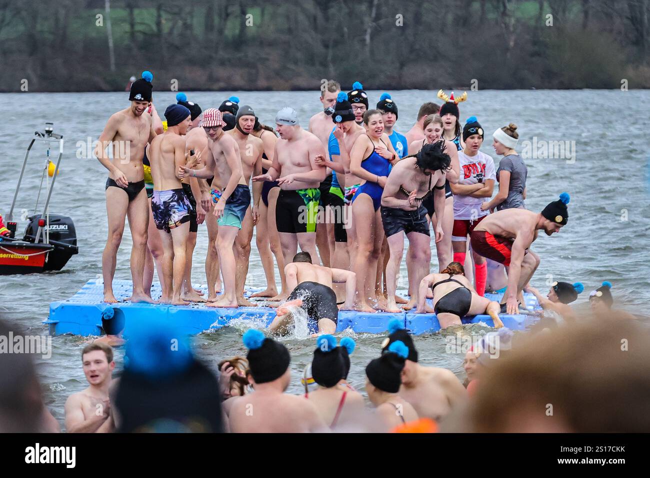Haltern, Germany, 01st Jan 2025. A brave few dare to swim to a mall floating jetty and shiver in ...