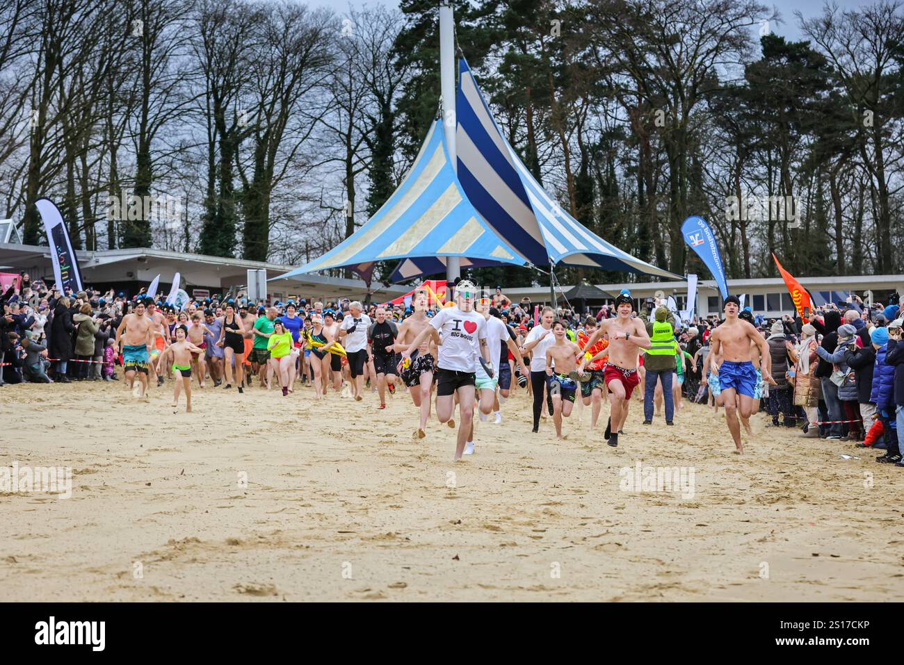 Haltern, Germany. 01st Jan, 2025. The swimmers race to the water. Participants, many in costumes ...