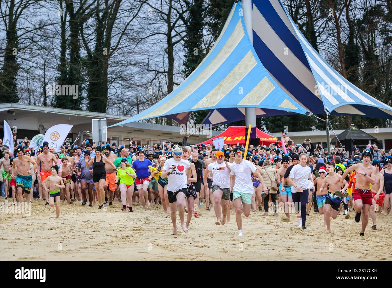 Haltern, Germany. 01st Jan, 2025. The swimmers race to the water. Participants, many in costumes ...