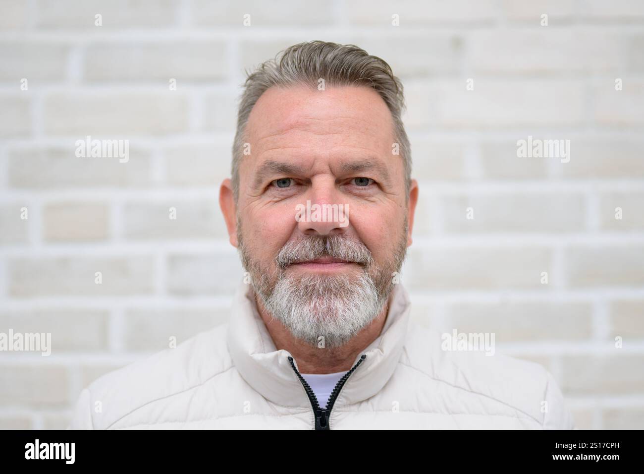 A portrait of a mature man with a grey beard and gentle smile, looking ...