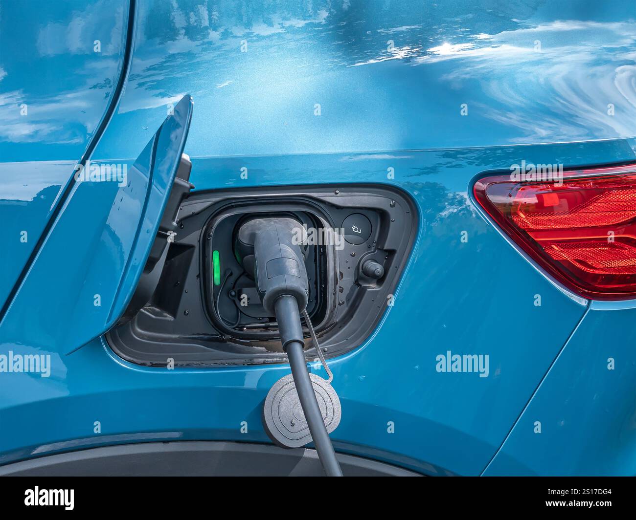Charging cable plugged into an electric car to charging a battery Stock ...