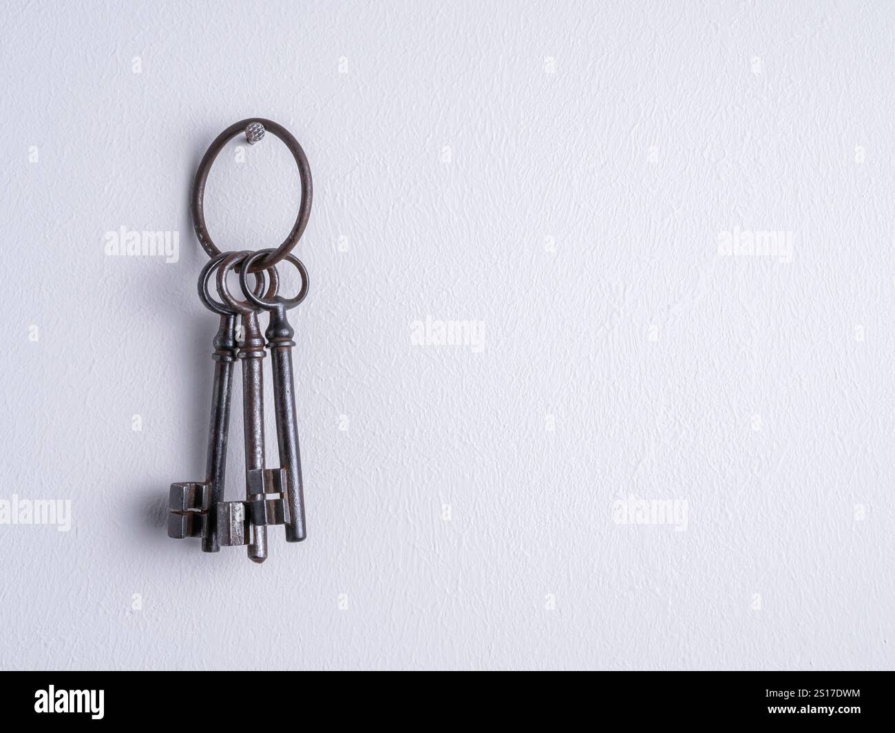 Vintage, rusty, iron keys with a ring on a white wall Stock Photo - Alamy