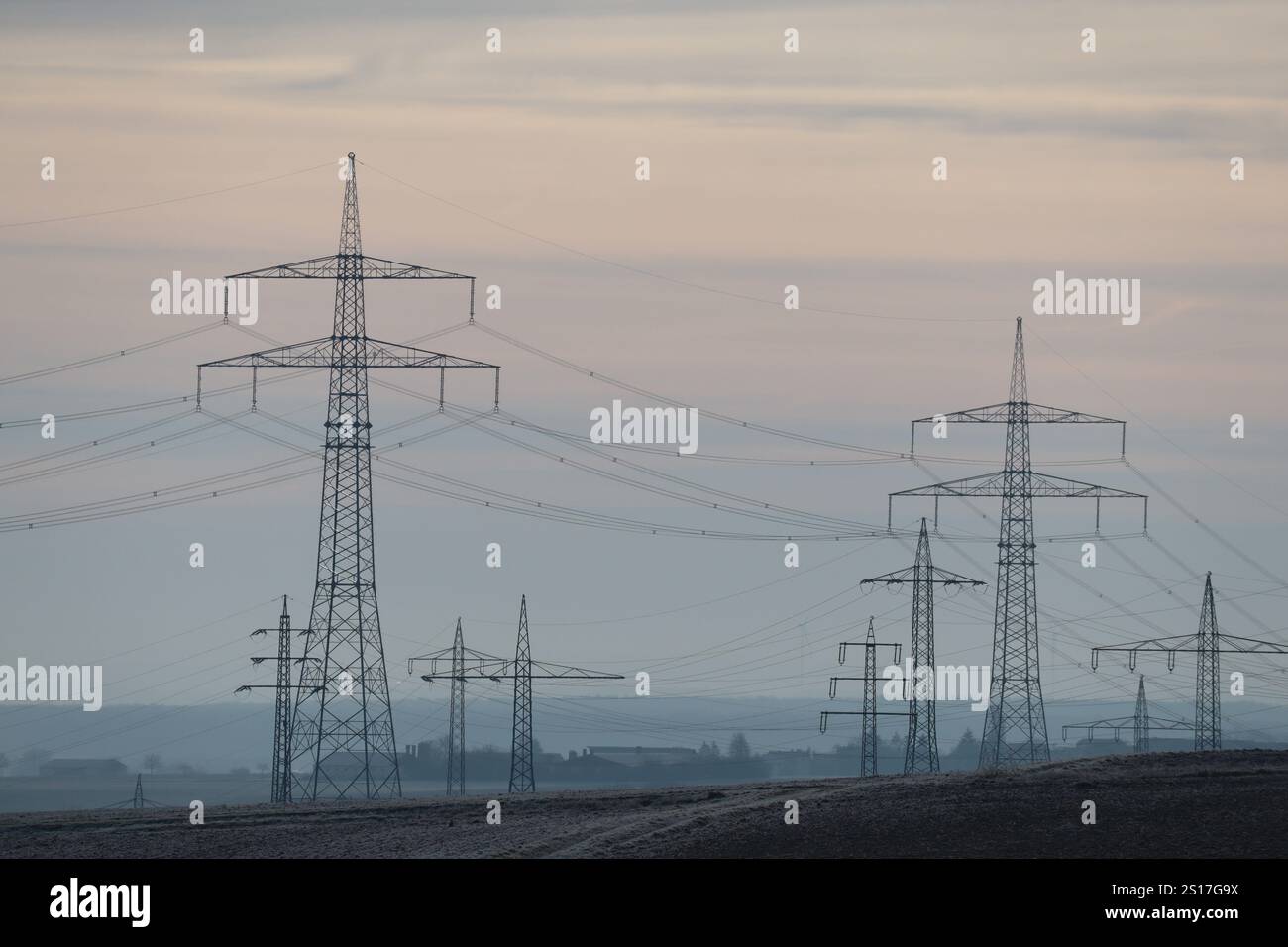 several high-voltage Pylons in the early Morning Stock Photo - Alamy