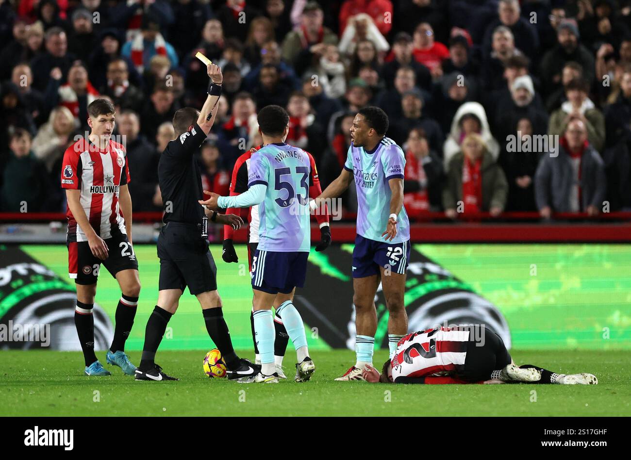 Referee Peter Bankes shows a yellow card to Arsenal's Jurrien Timber ...
