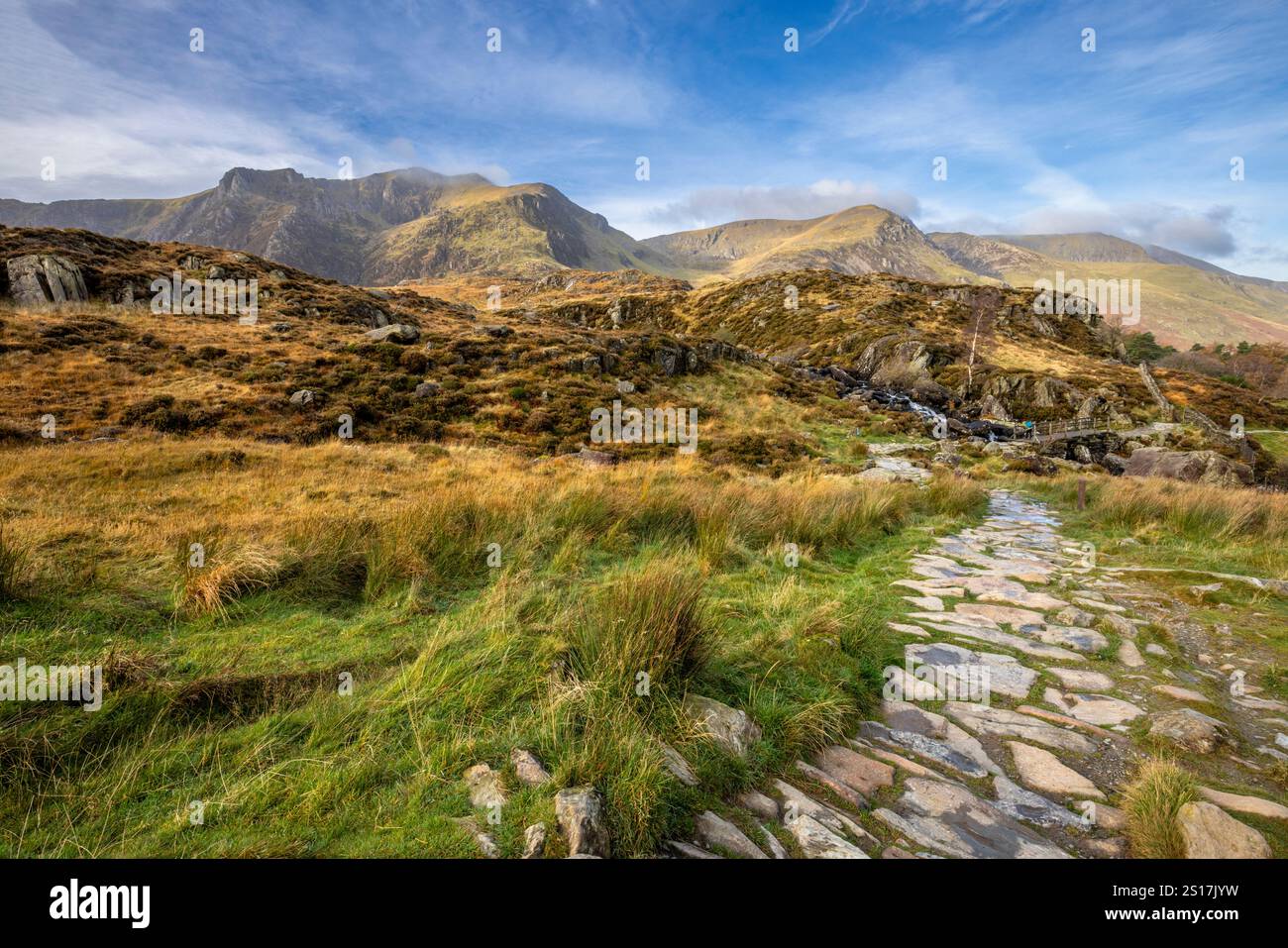 The stone path leading to Afon Idwal footbridge with Y Garn mountain in ...