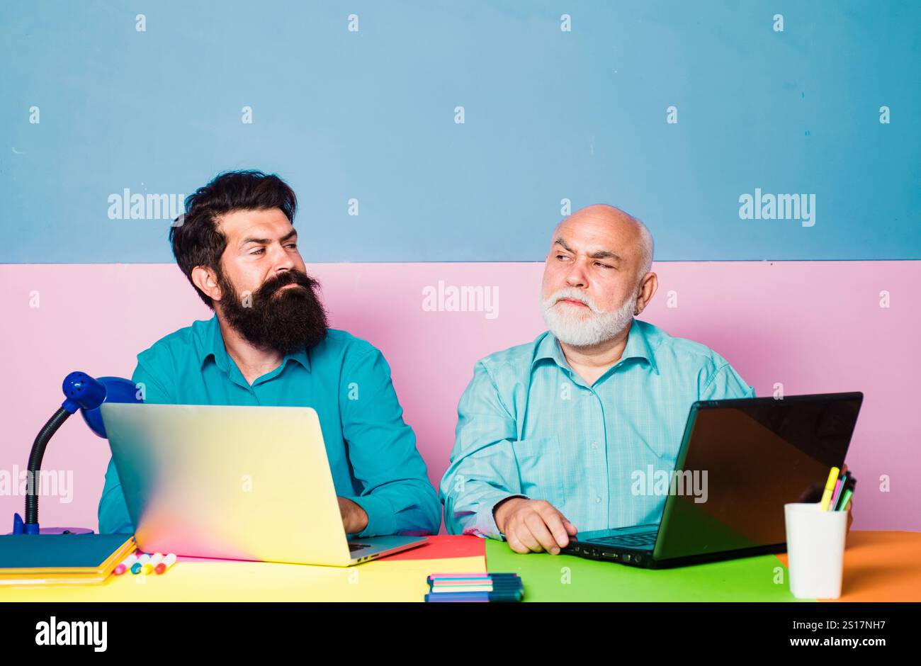 Two businessmen working at workplace. Businessmen using laptop at work ...