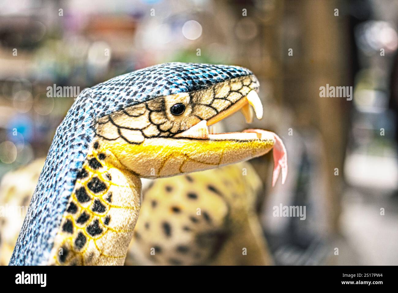 toy cobra head with an open mouth and a protruding tongue on a blurred ...