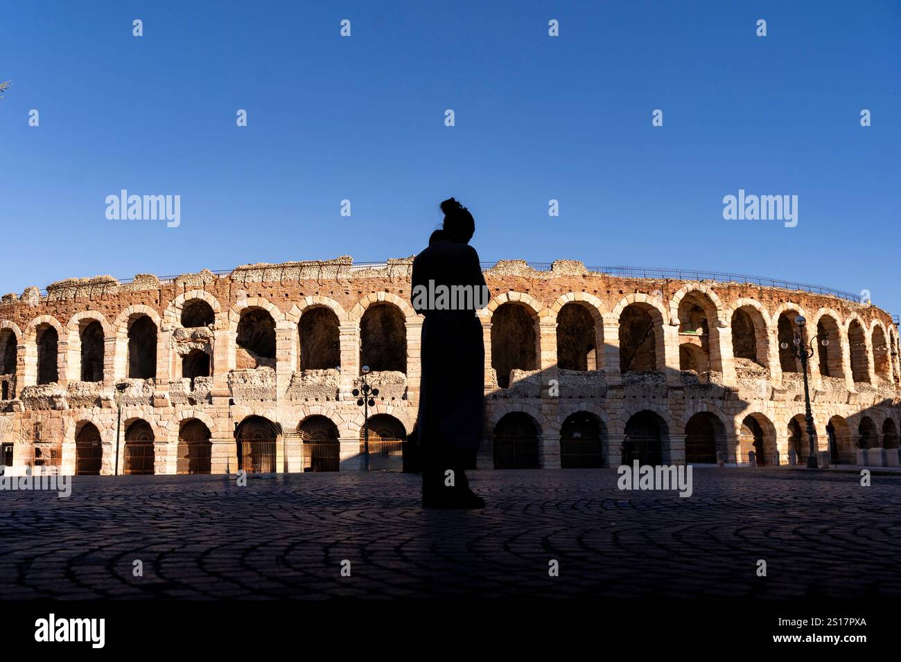 silhouette of woman on vacation using mobile phone to photograph famous ...