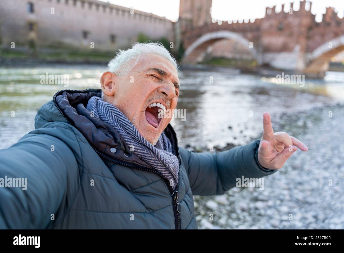 happy middle aged man on vacation taking a selfie on a river beach in ...