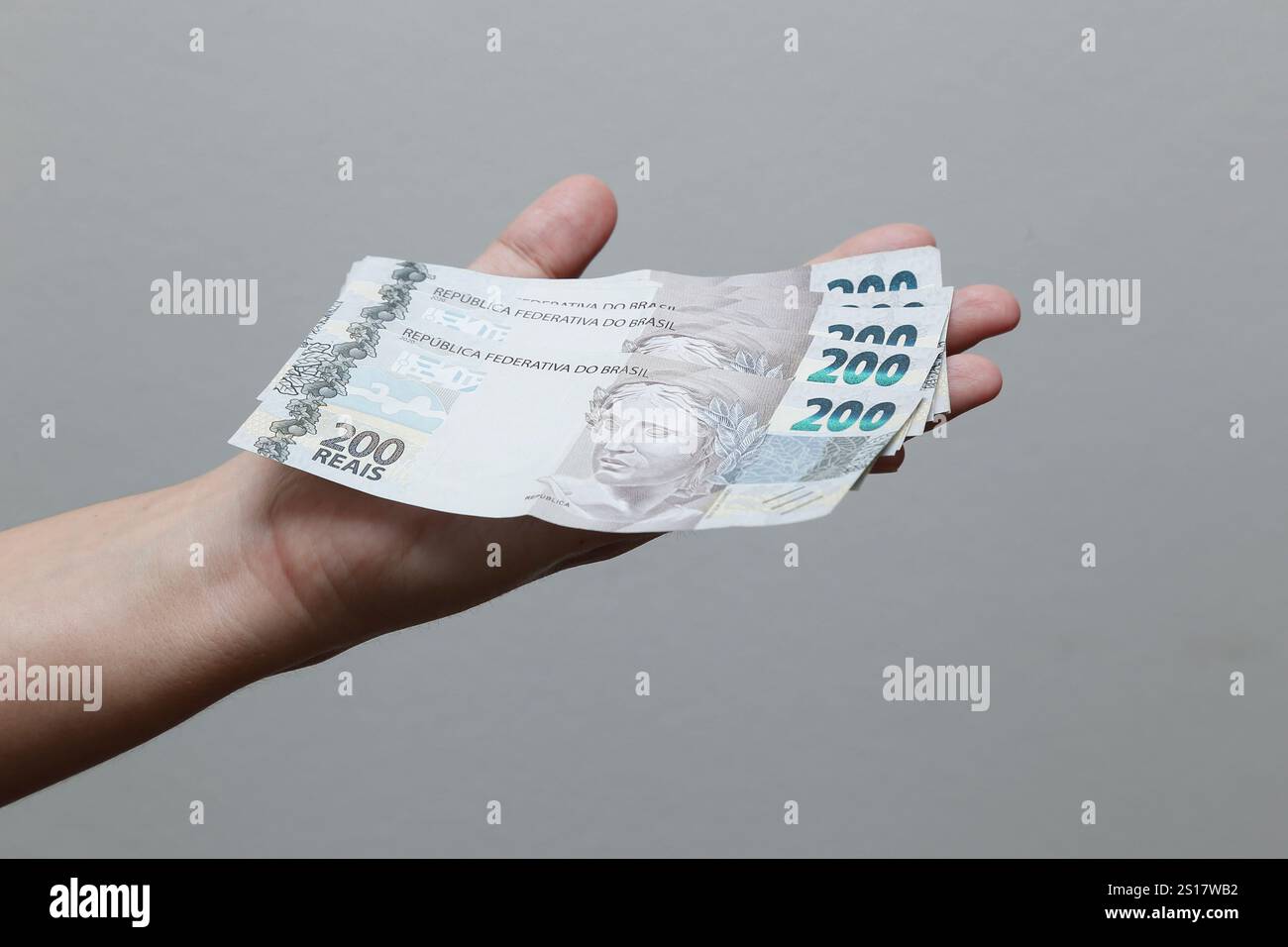 Hands holding Brazilian real notes, Brazil BRL banknote, Brazilian ...