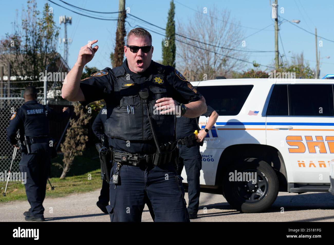 Harris County Sheriff's officers clear the media from the neighborhood ...